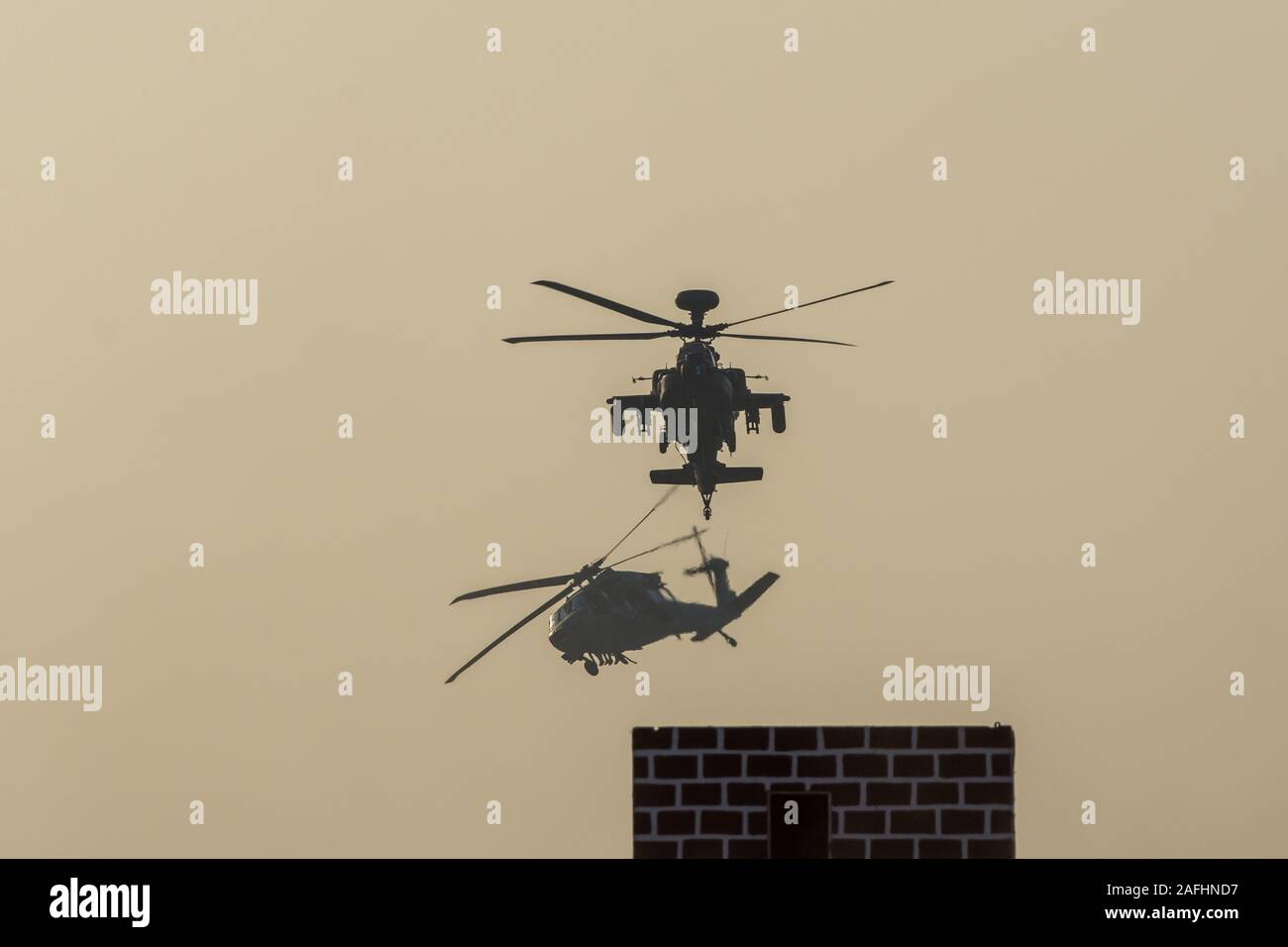 Two Military choppers in combat and war flying into the smoke and chaos ...