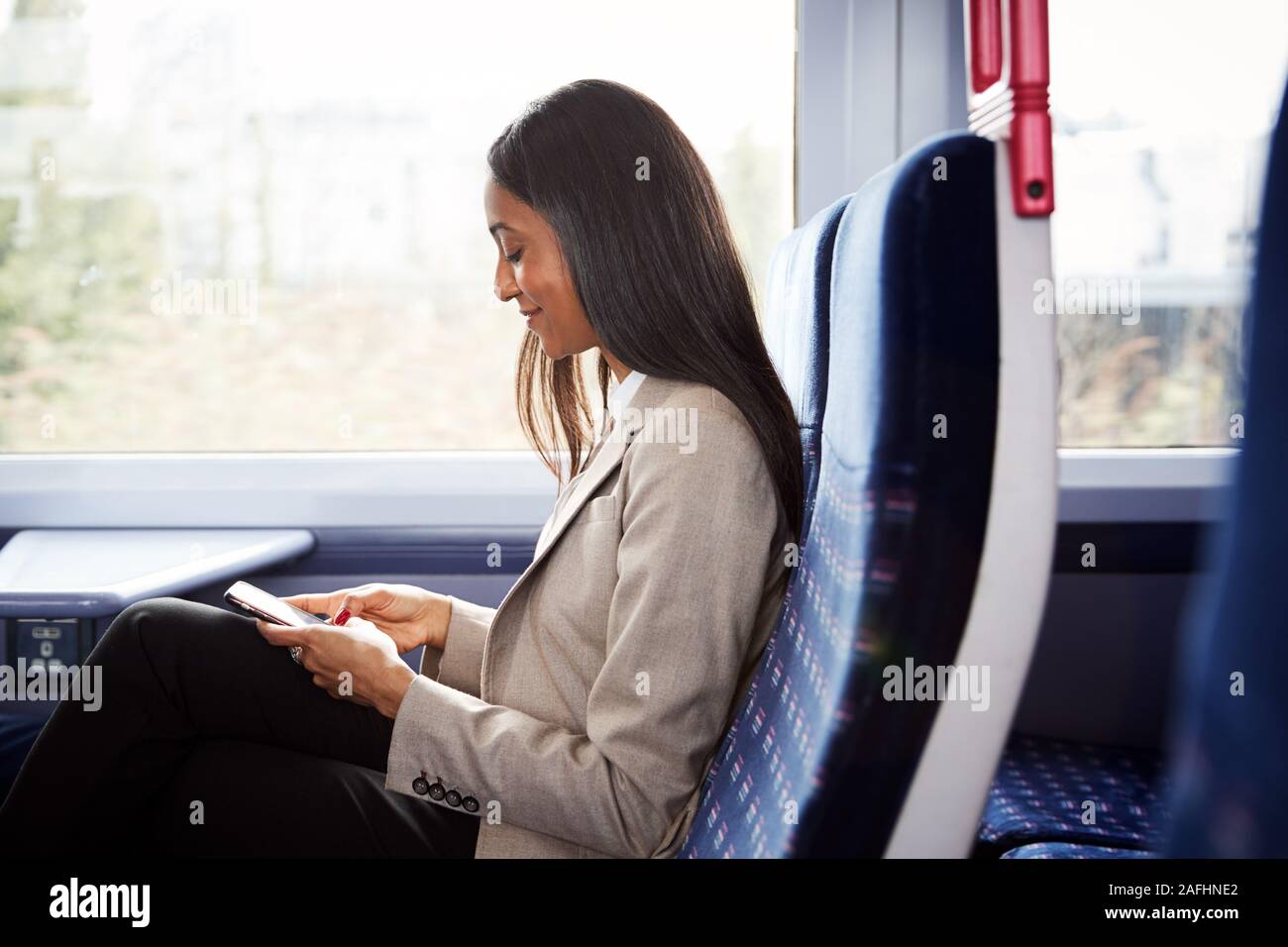 Commuter checking his mobile phone hi-res stock photography and images ...