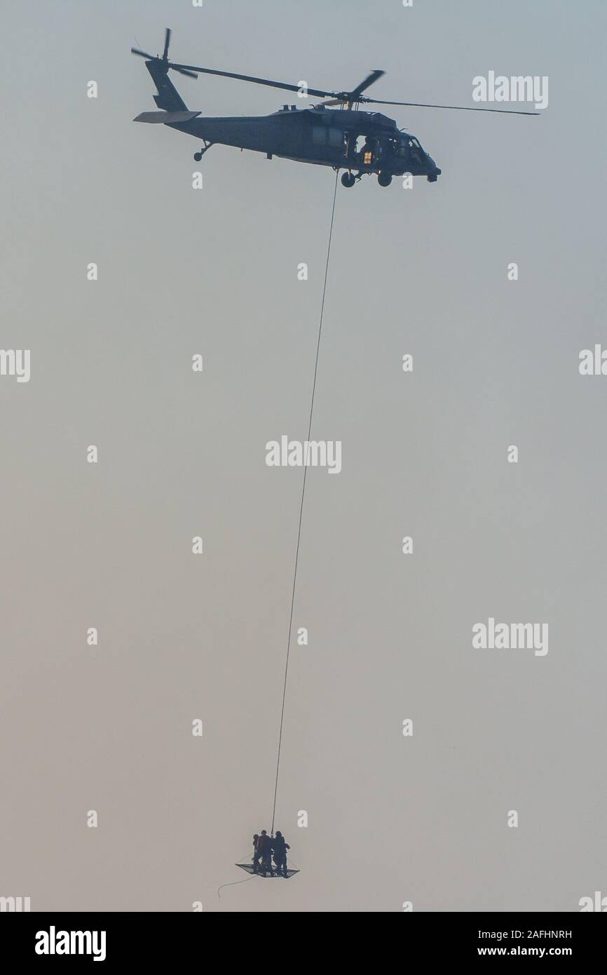 Military team in conflict resucing people by helicopter. flying through ...