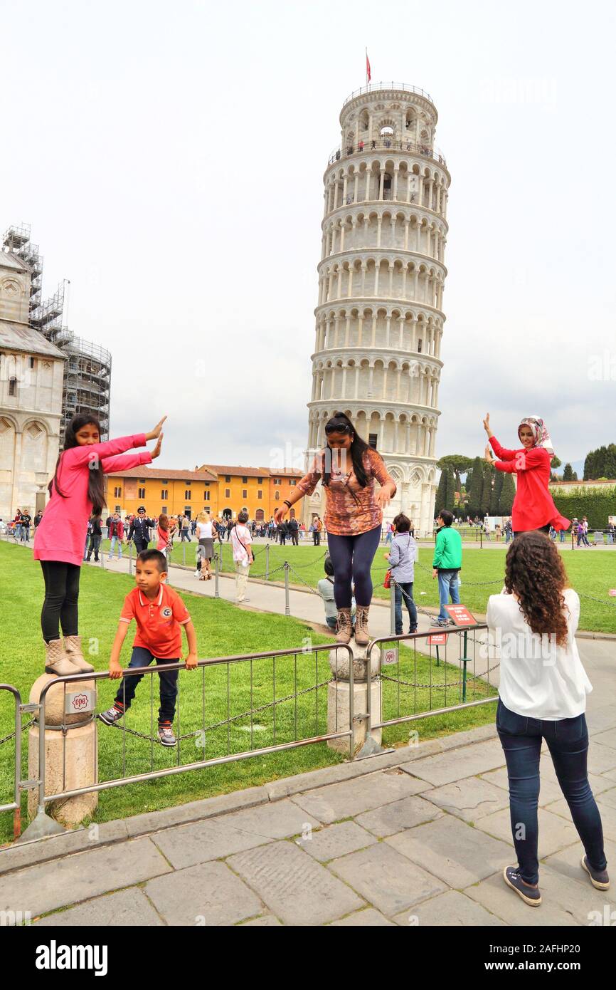 PISA, ITALY - APRIL 25, 2015: Tourists pose and take photos with ...
