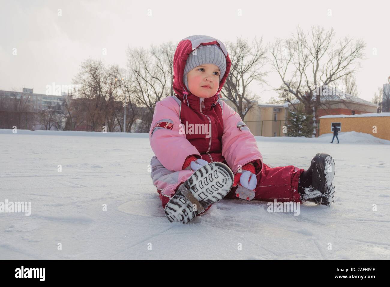 little child is sitting on the ice in winter Stock Photo - Alamy
