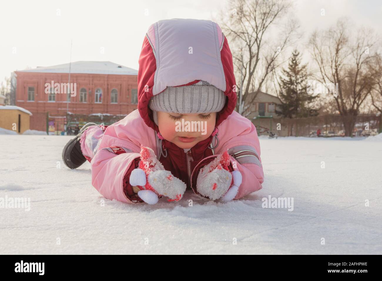 little child lies on ice in winter Stock Photo - Alamy