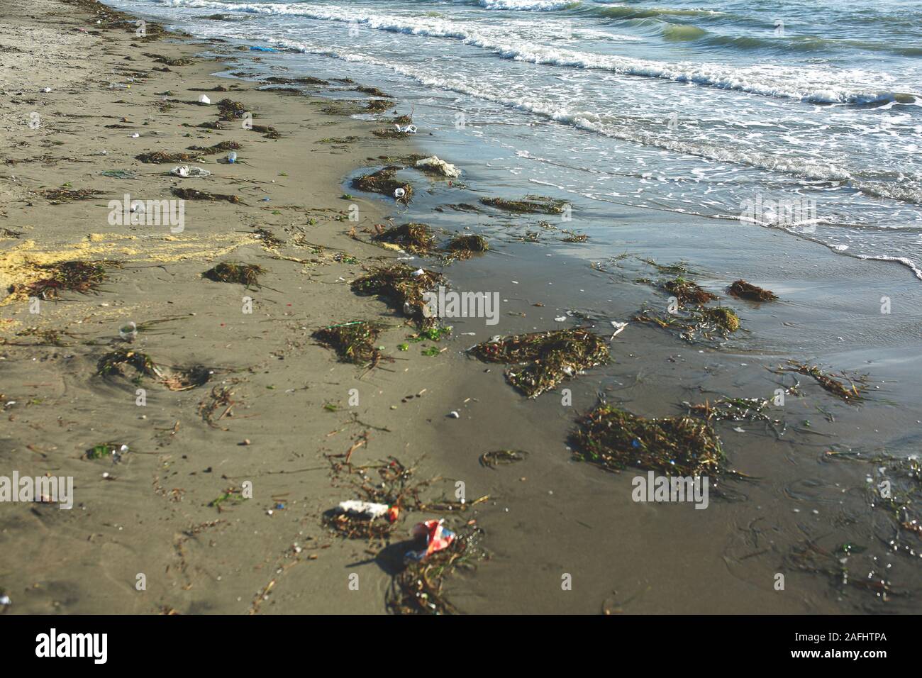 Garbage on tropical beach. Old tire and construction debris on seashore ...