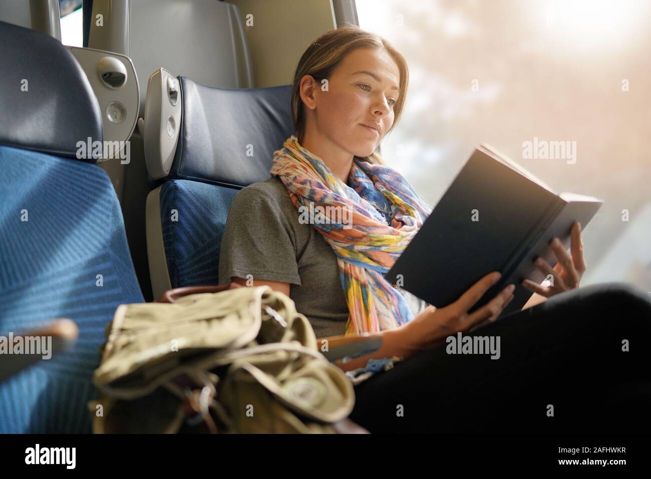 Woman reading book on train hi-res stock photography and images - Alamy