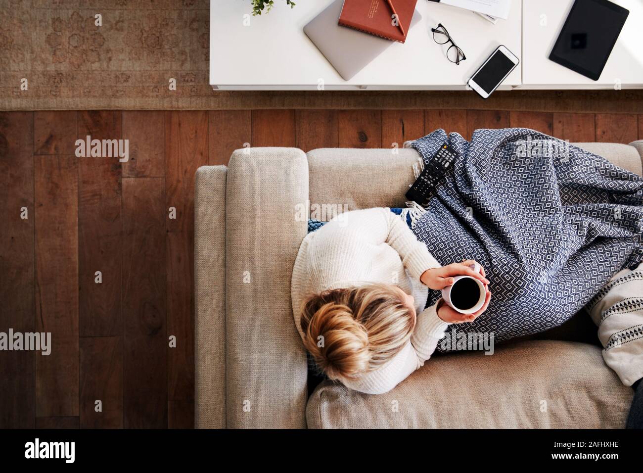 Overhead Shot Looking Down On Woman At Home Lying On Sofa Watching ...