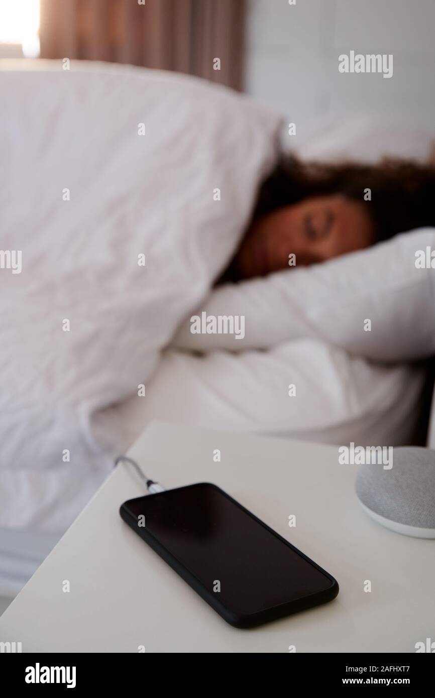 Woman Asleep In Bed With Mobile Phone On Bedside Table Stock Photo - Alamy
