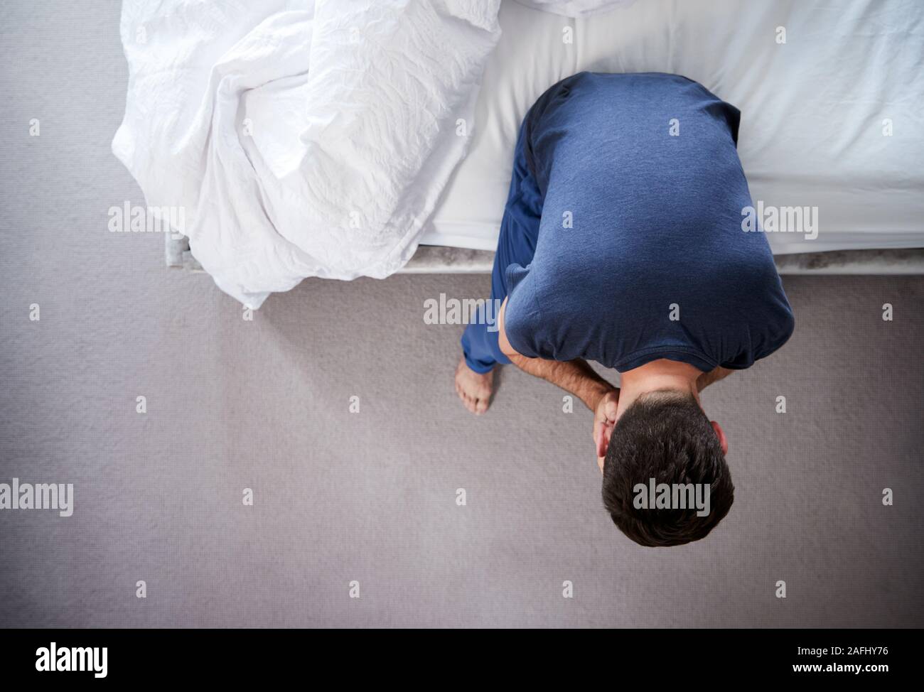 Man sitting alone on bed hi-res stock photography and images - Alamy