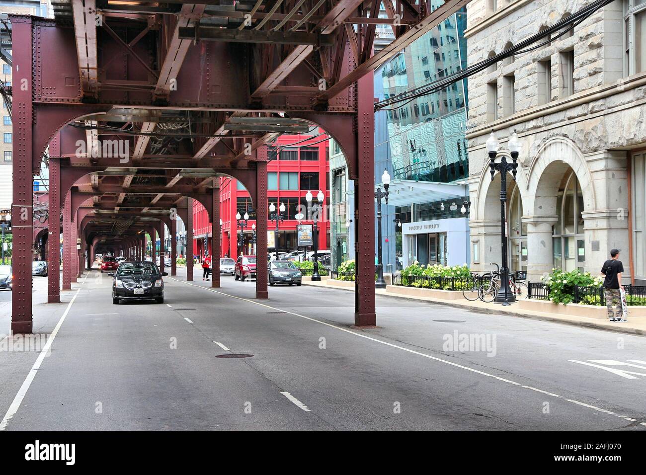 CHICAGO, USA - JUNE 28, 2013: Cars drive below elevated train tracks in ...
