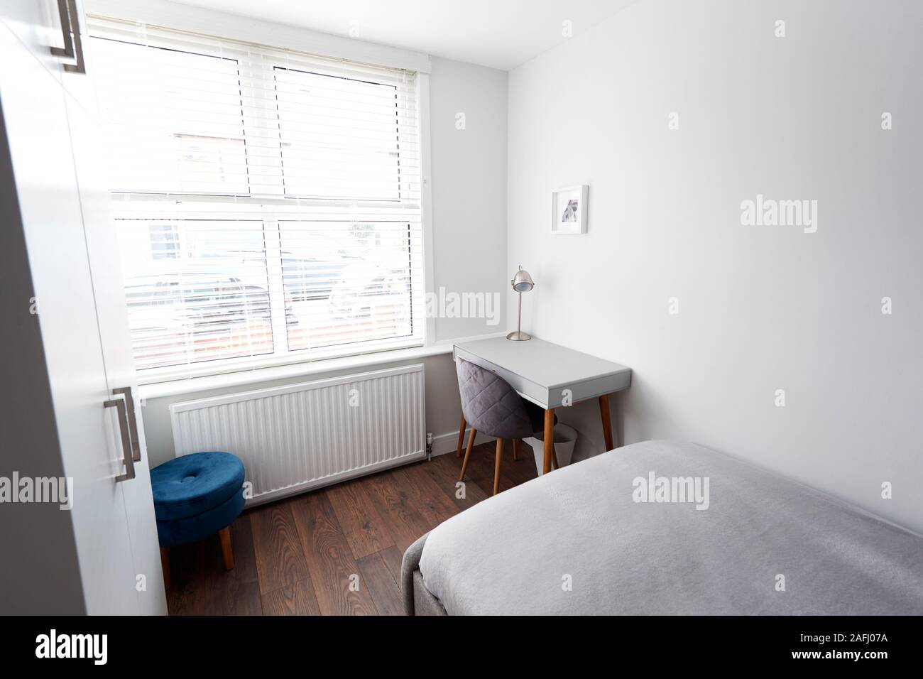 Modern bedroom with bed and desk by window Stock Photo - Alamy