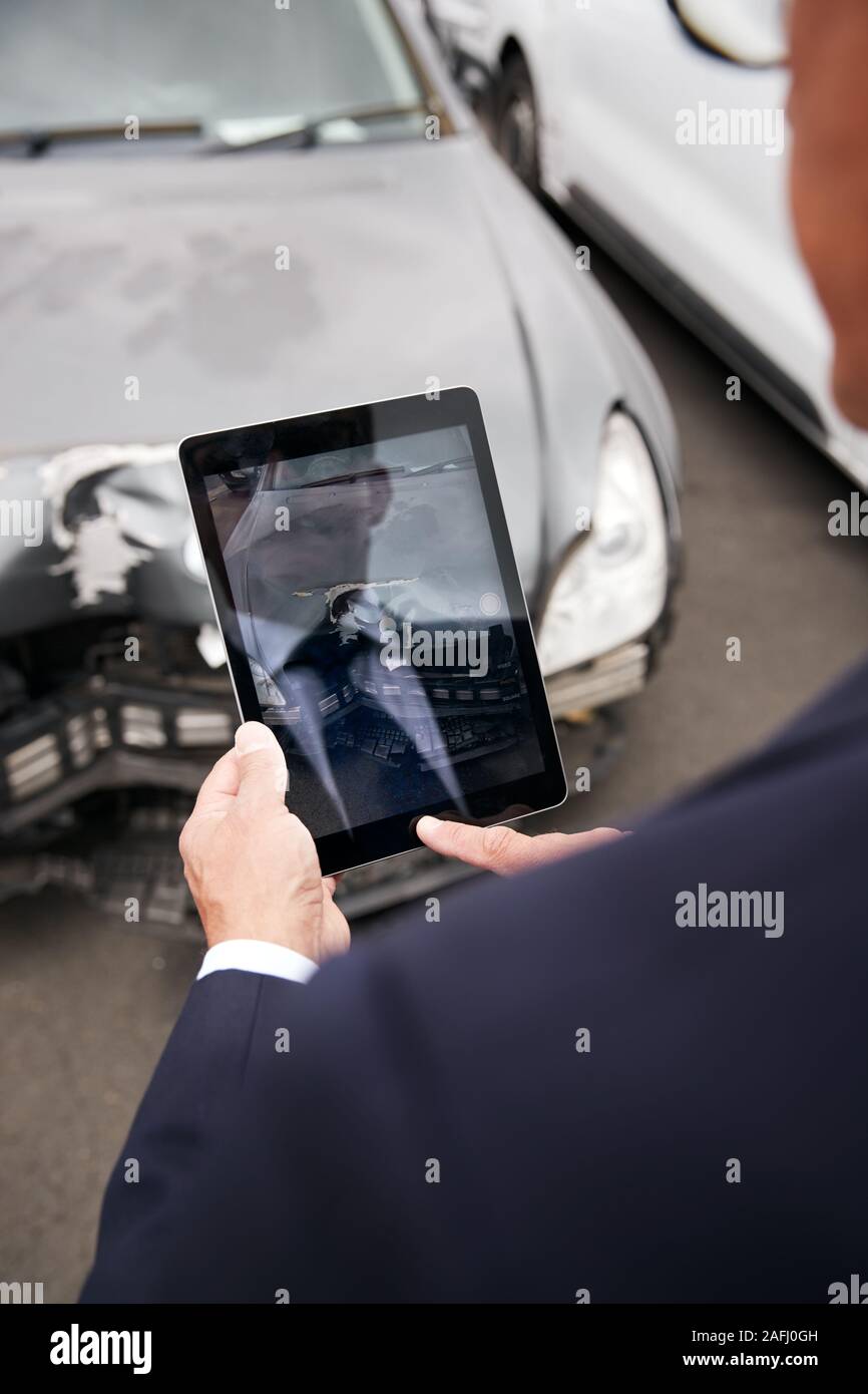 Insurance Loss Adjuster Taking Picture With Digital Tablet Of Damage To ...