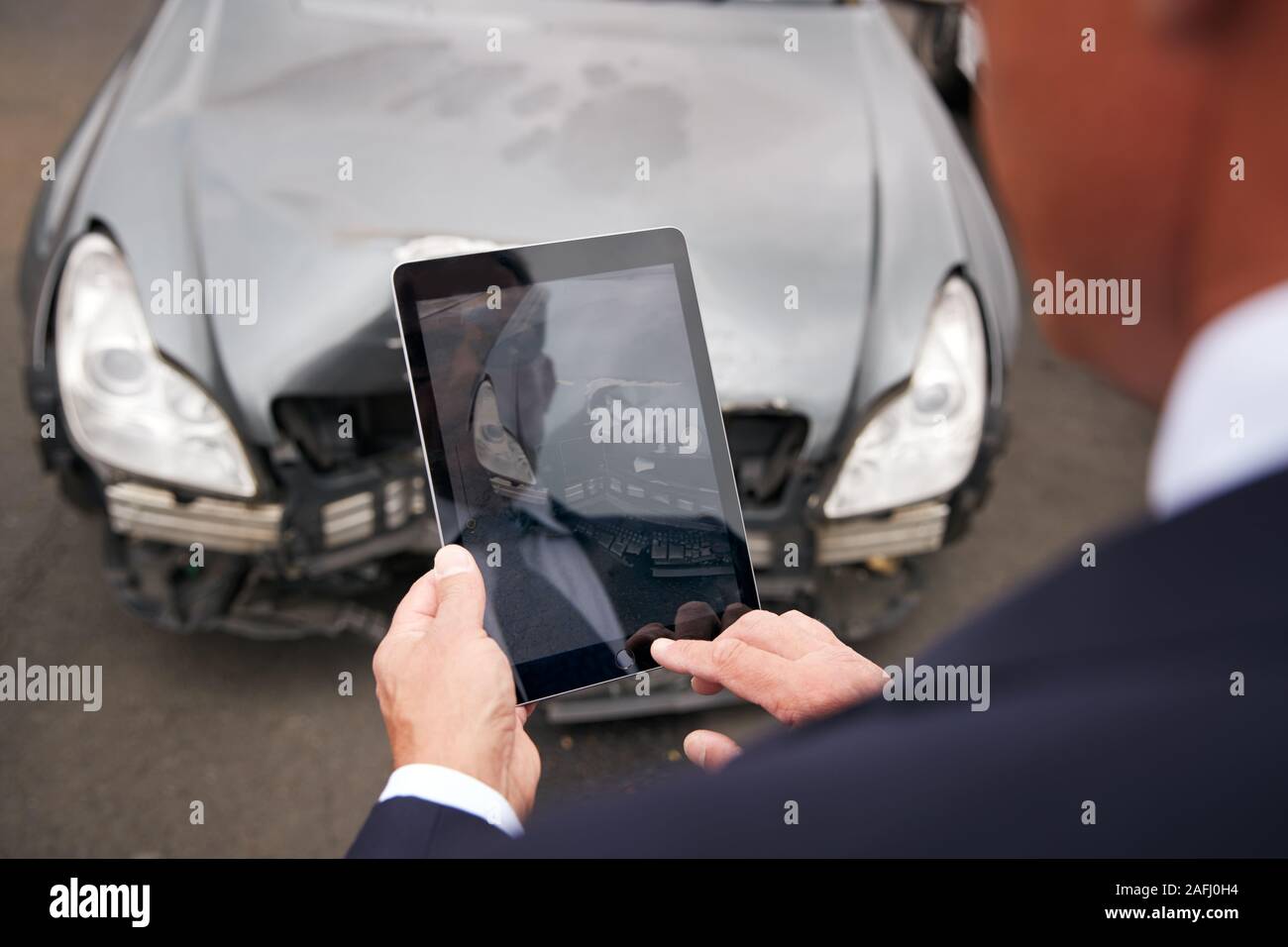 Insurance Loss Adjuster Taking Picture With Digital Tablet Of Damage To ...