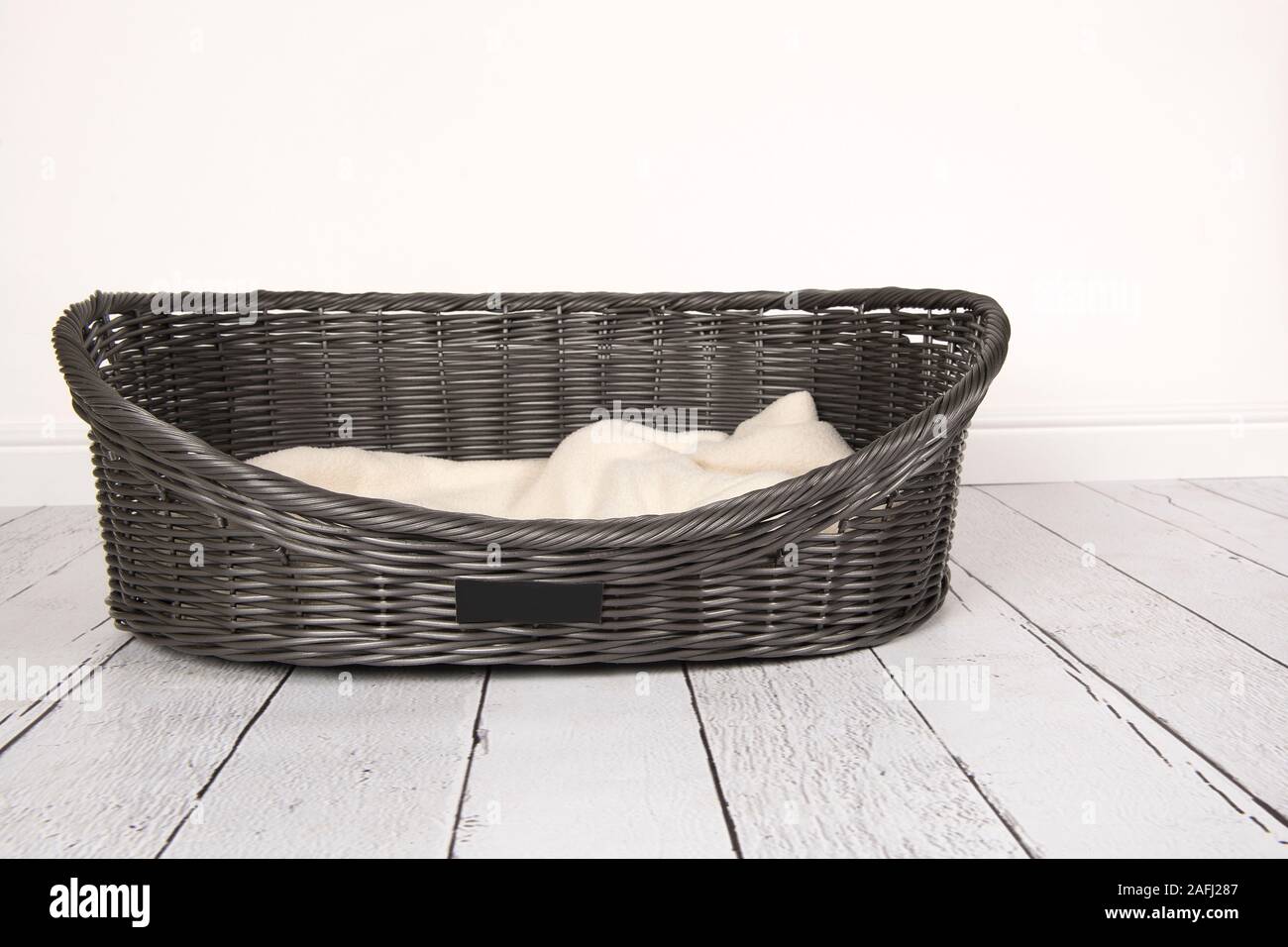 Empty dog bed in a white studio interior Stock Photo - Alamy