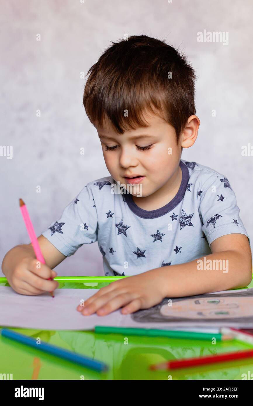 Little boy drawing with color pencils. Little boy is holding color ...