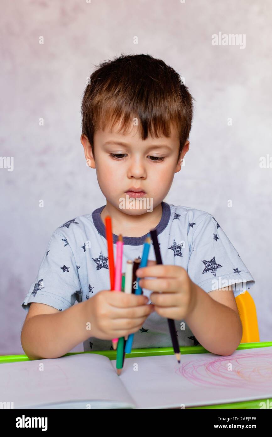 Little boy drawing with color pencils. Little boy is holding color ...