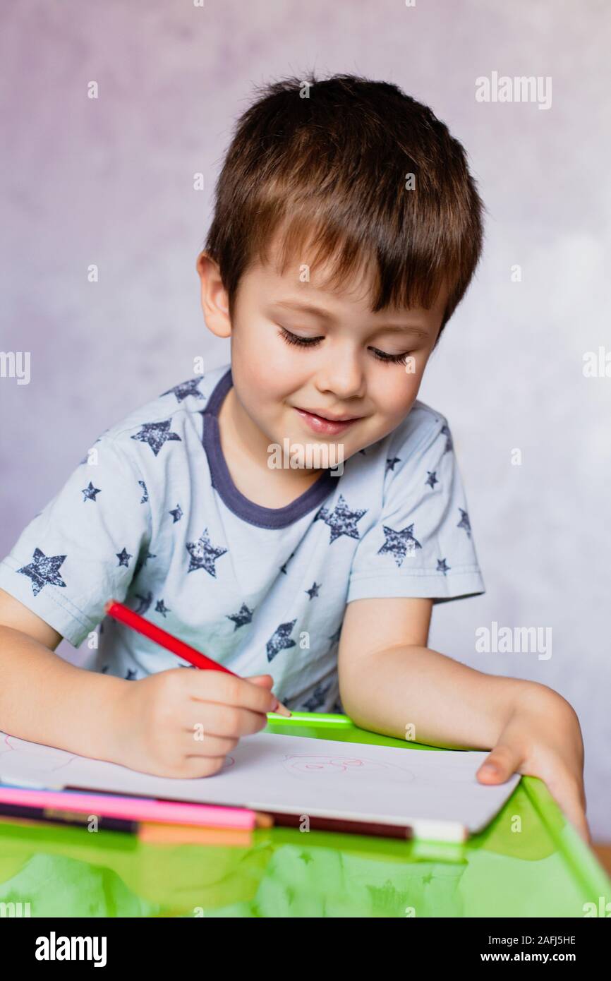 Little boy drawing with color pencils. Little boy is holding color ...