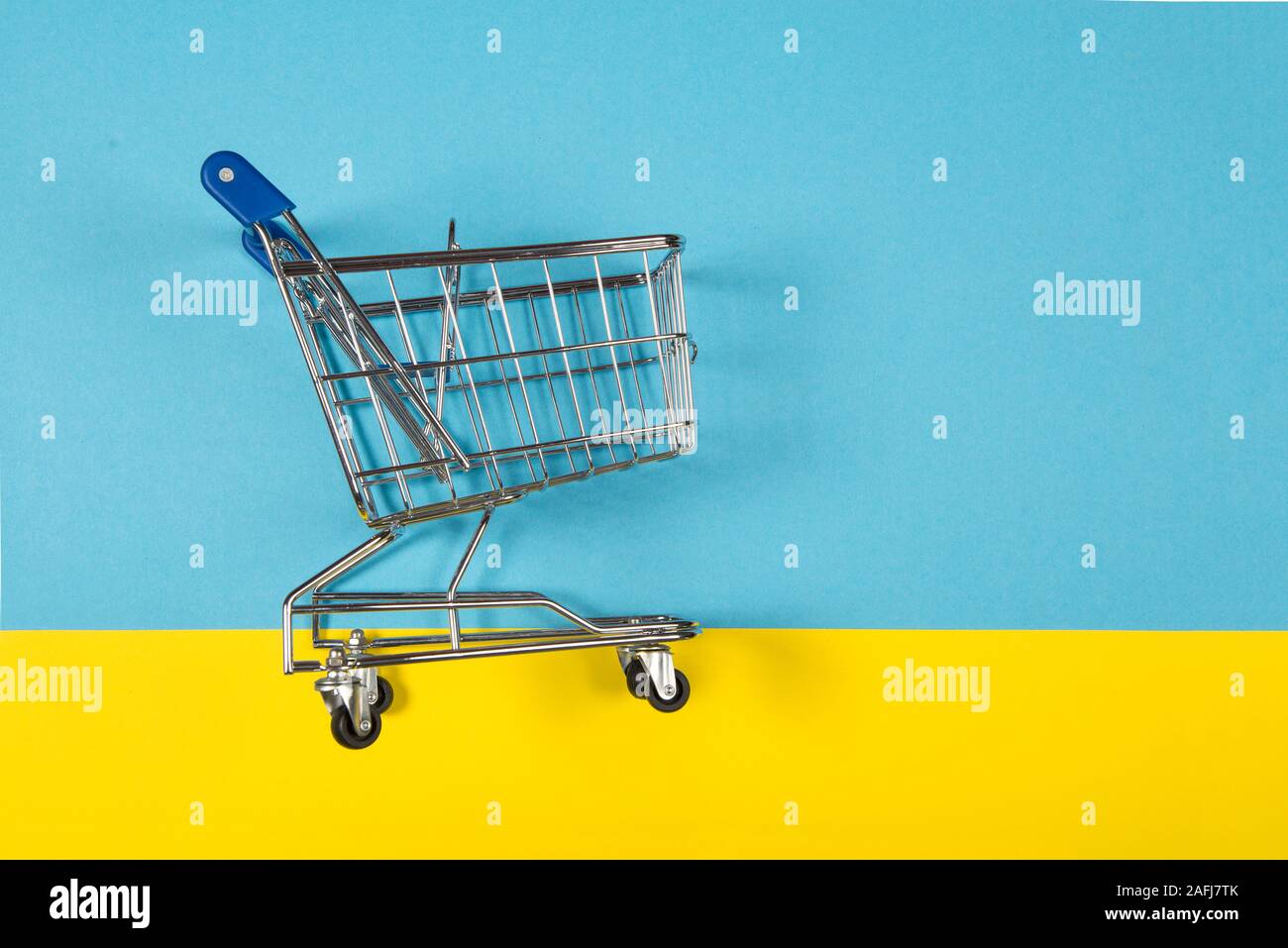 Empty push cart on a blue and yellow background as a concept for ...