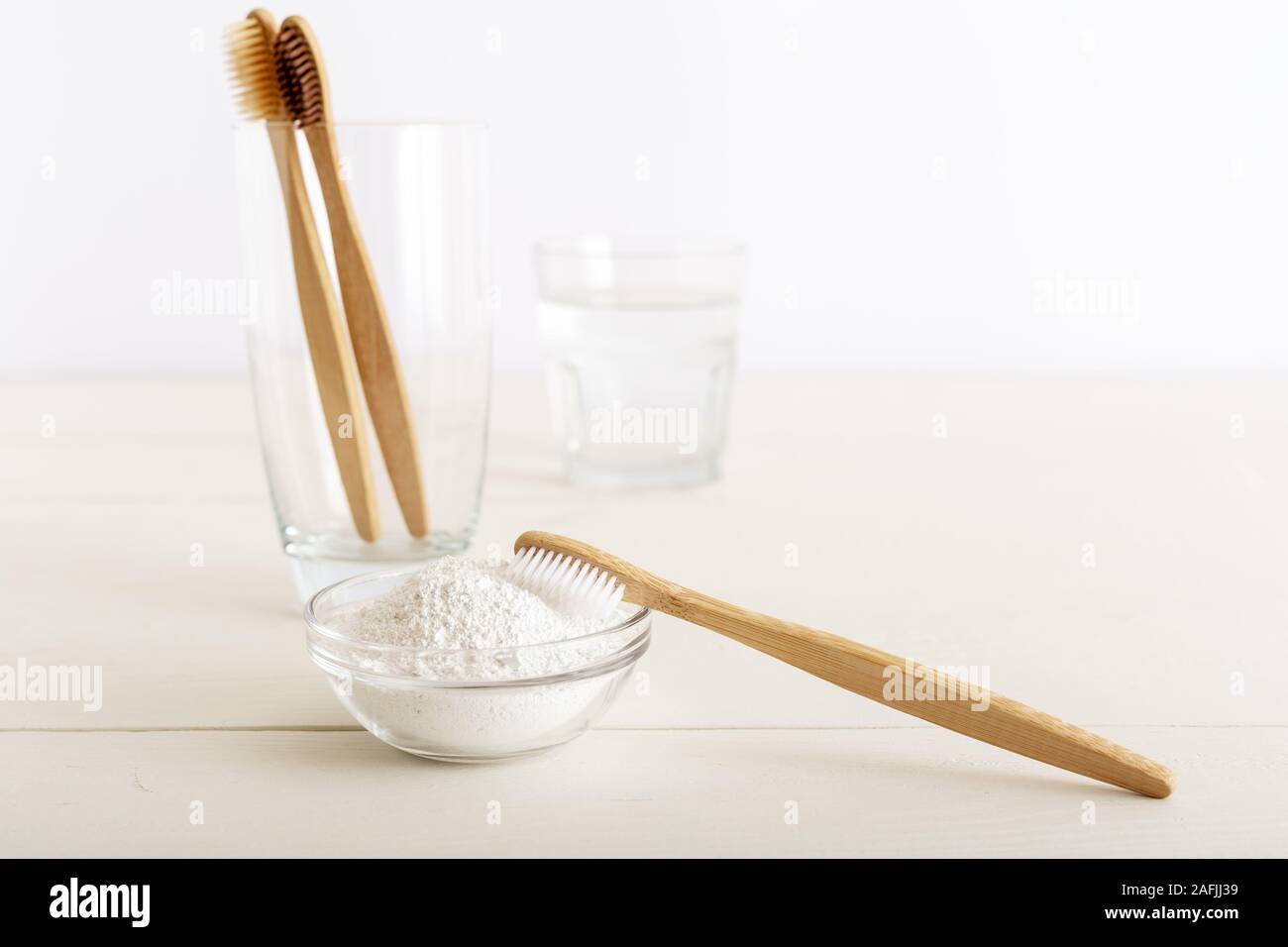 Bamboo toothbrushes, glass of water, dentifrice tooth powder on white ...