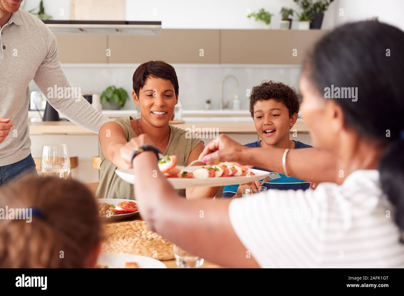 Father Serving As Multi-Generation Mixed Race Family Eat Meal Around ...