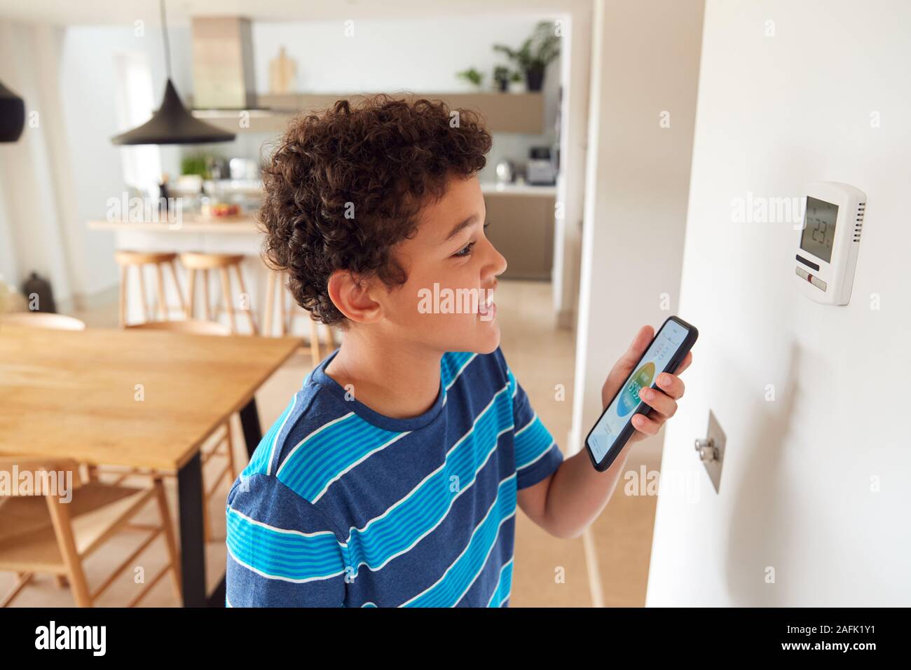 Boy Changes Temperature On Central Heating Thermostat Control Using ...