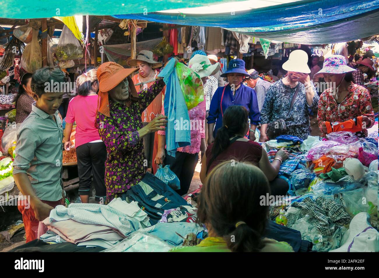 Crowd of women shopping at clothes stalls in the busy central market in ...