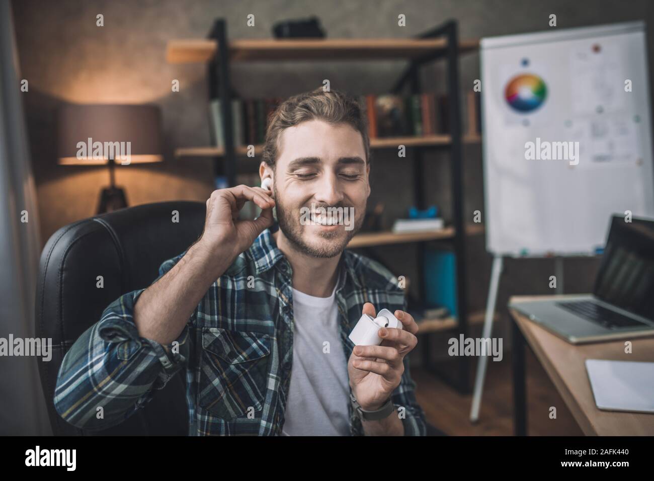 Young man playing guitar at office hi-res stock photography and images ...