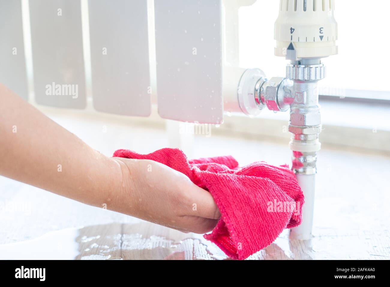 Female hand with rag cleaning water from heating radiator Stock Photo ...