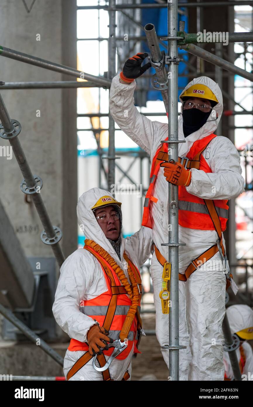 Workers in white protective uniform fixing pipes Stock Photo - Alamy