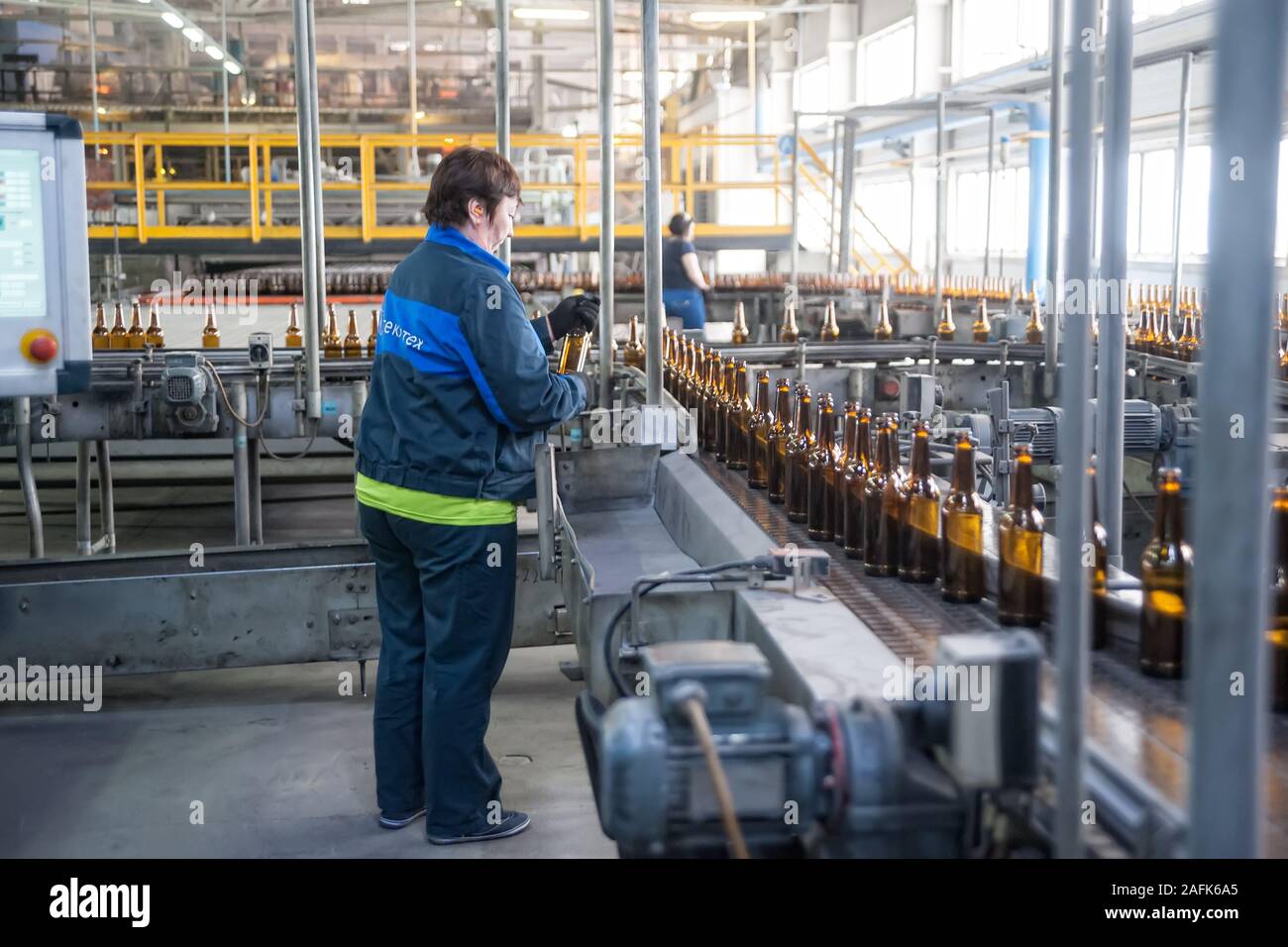 Operator monitors moving empty bottles on conveyor Stock Photo - Alamy