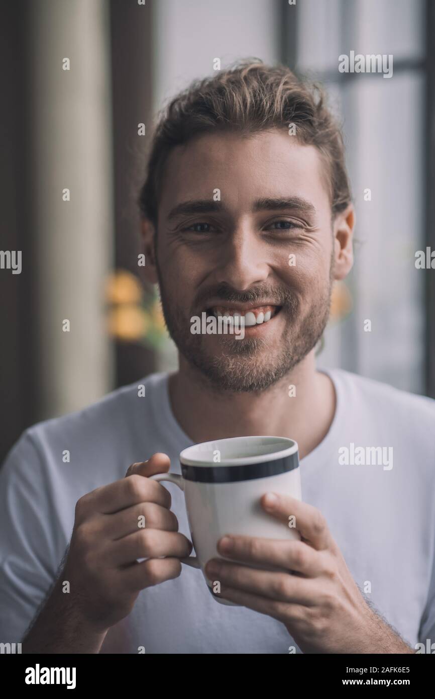 Thoughtful smiling man drinking his morning cup of coffee Stock Photo ...