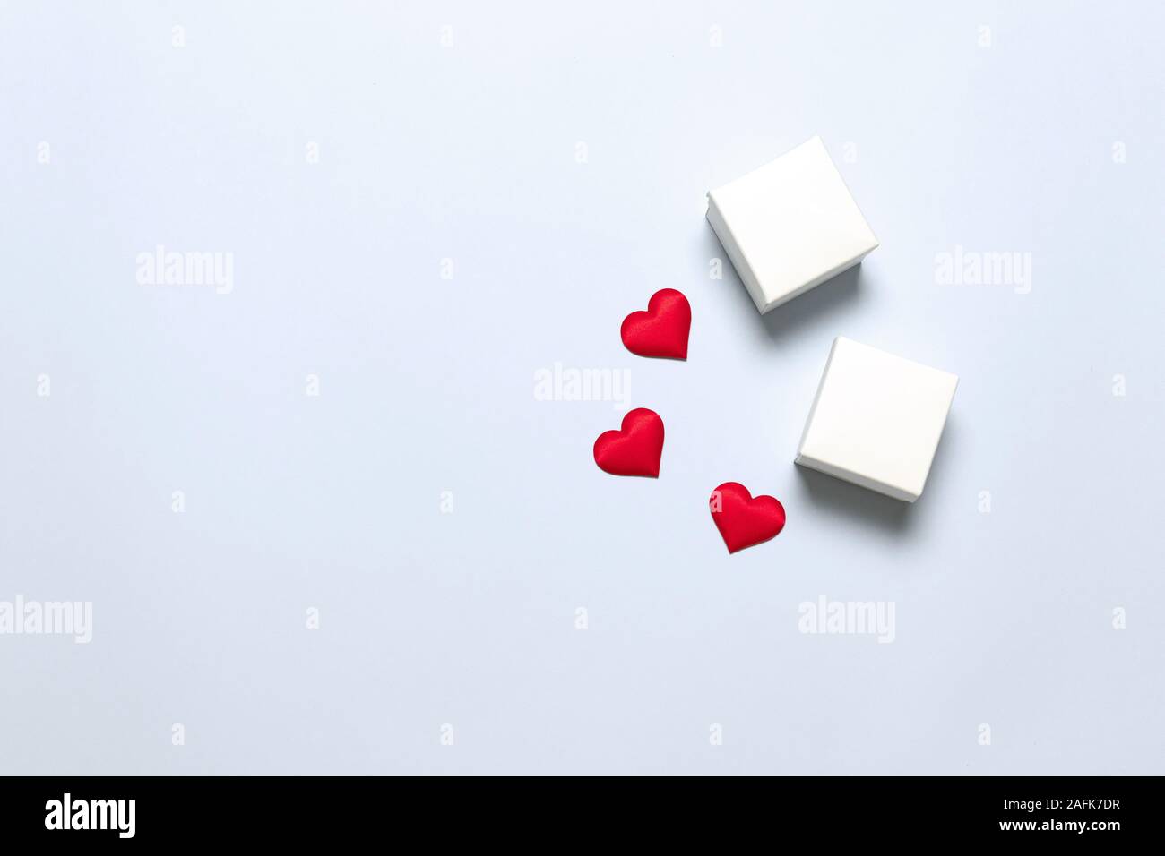 Minimal festive composition with white empty surprise boxes and heart ...
