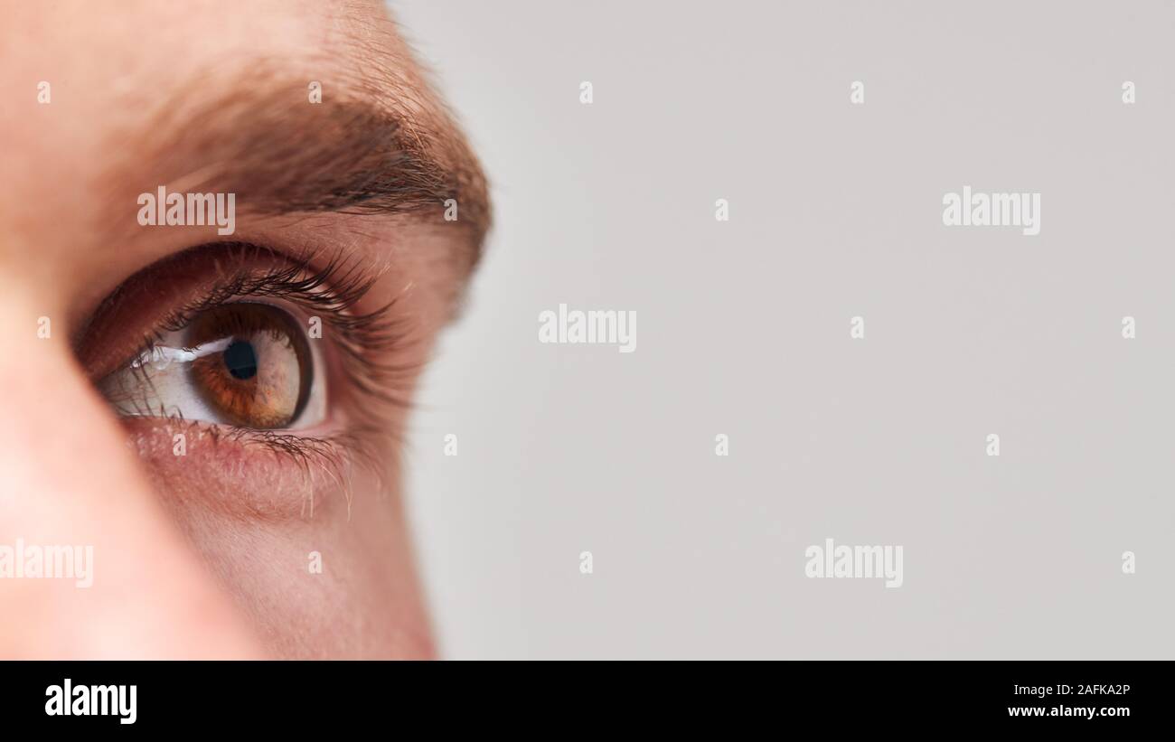 Extreme Close Up Of Eye Of Man Against White Studio Background Stock ...