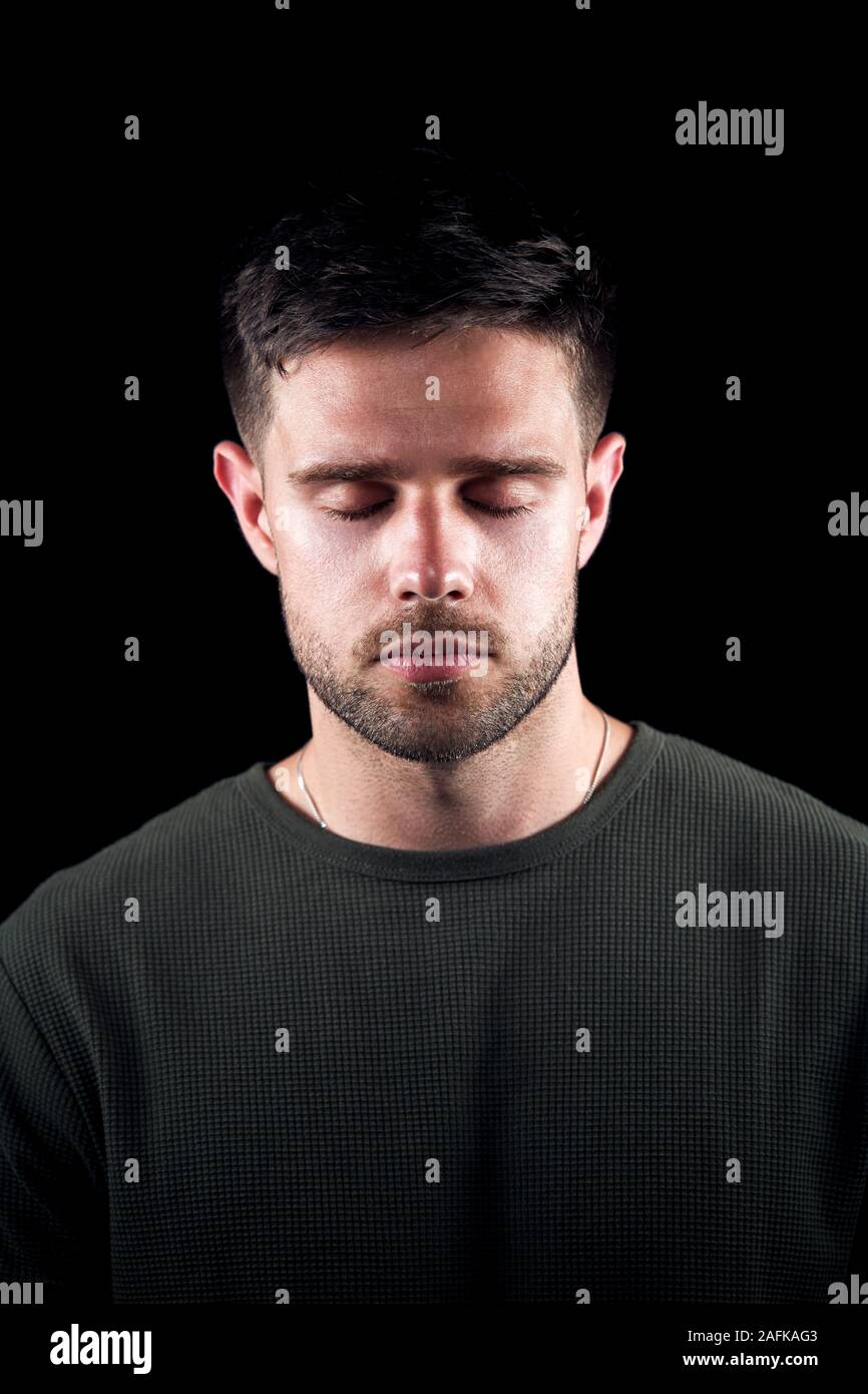 Studio Portrait Of Young Man With Serious Expression And Closed Eyes ...
