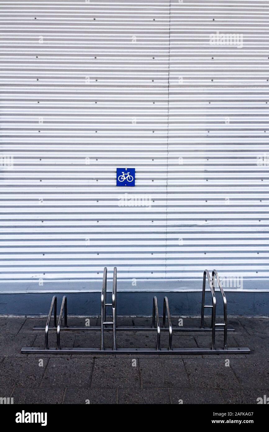 Iron bike rack by the gray corrugated iron wall Stock Photo - Alamy