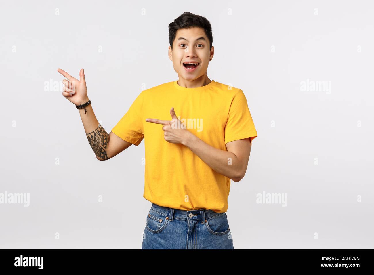 Excited, happy smiling asian young millennial man, wear yellow t-shirt ...