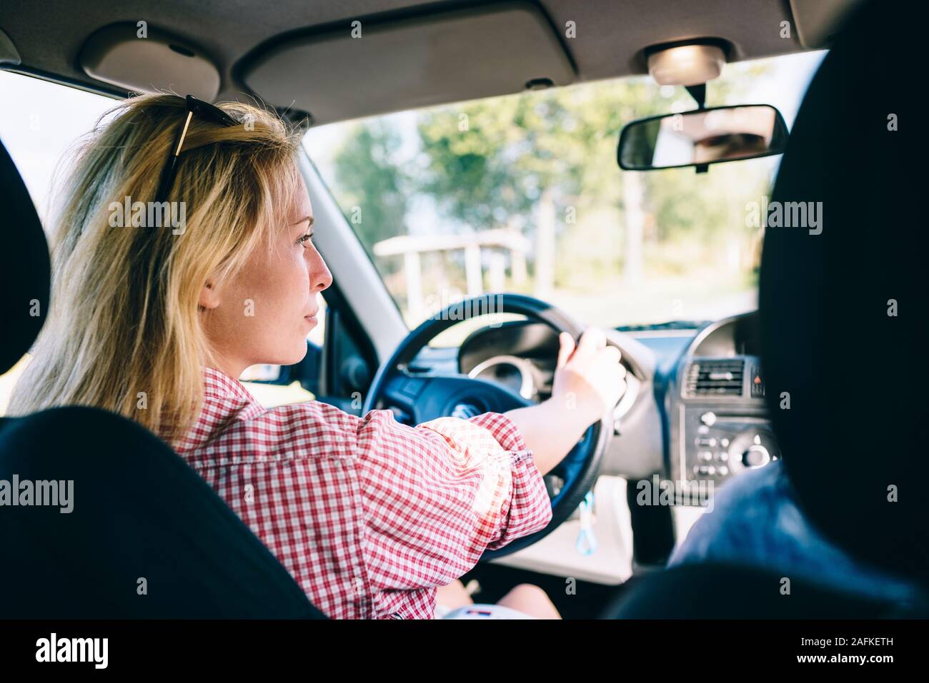 Young blond woman driving car. Hipster girl driver travel in vehicle ...