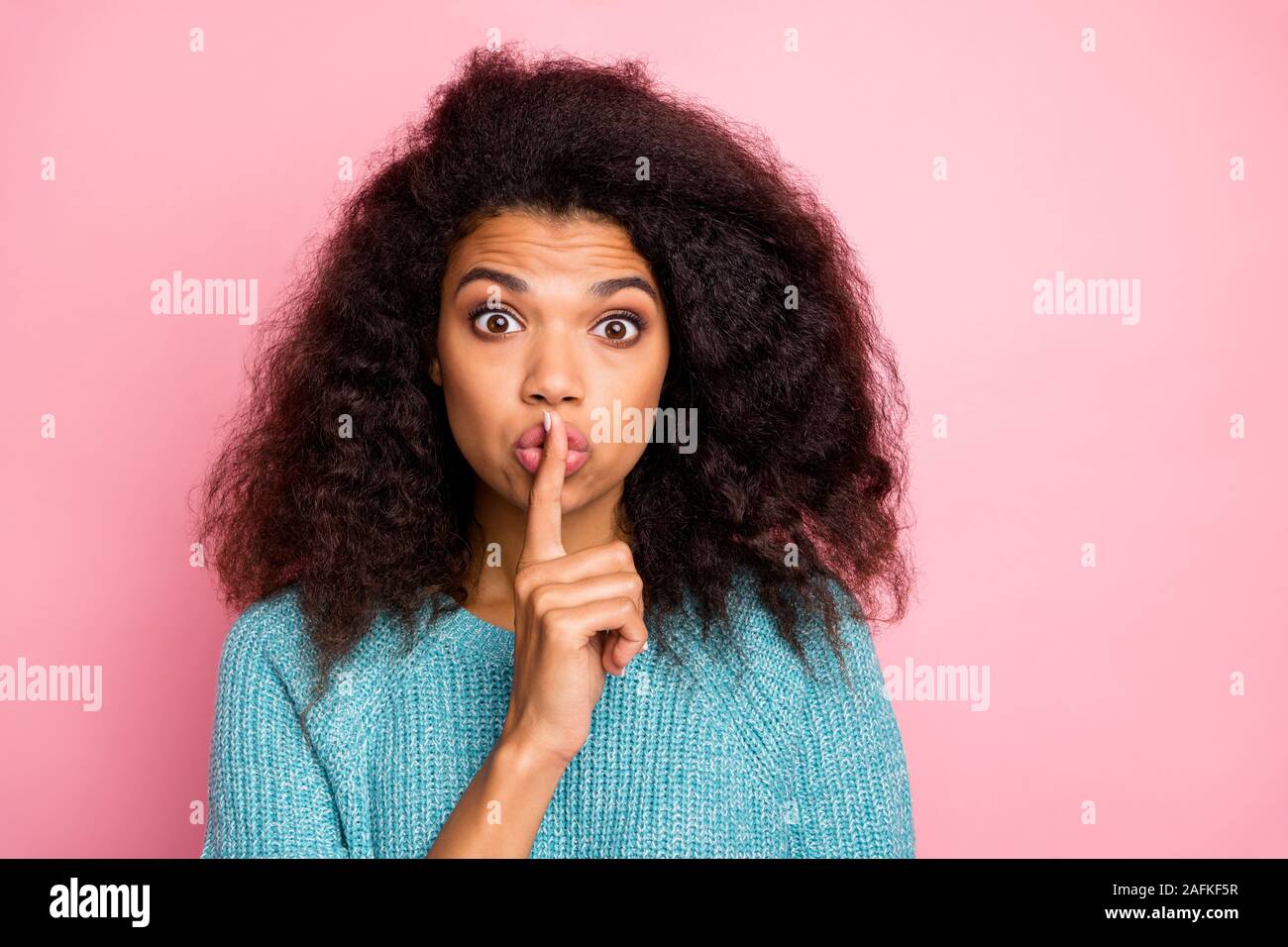 Photo of woman in blue jumper showing you shh sign to stop your ...