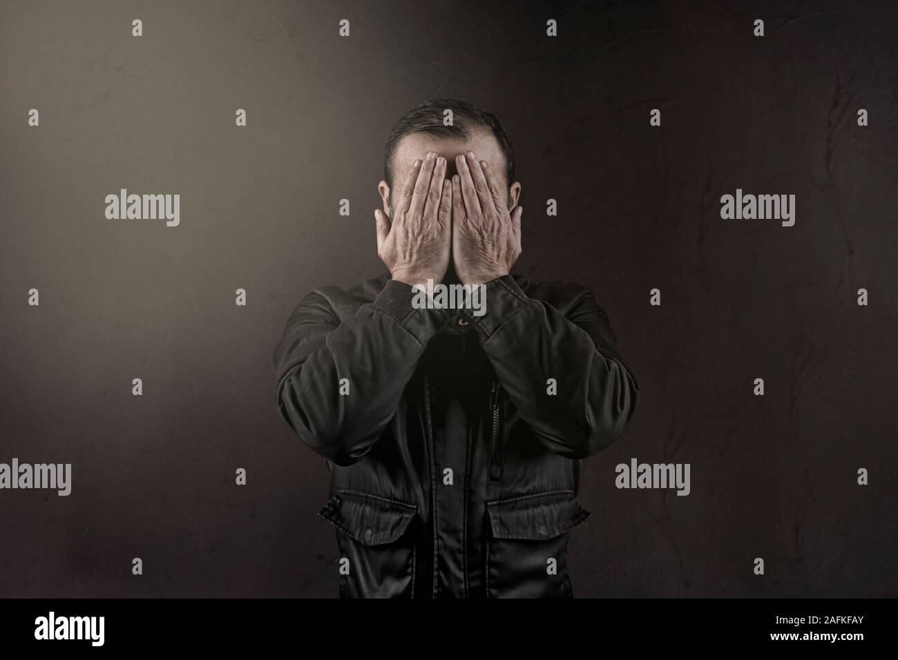 man hiding his face with his hands Stock Photo - Alamy