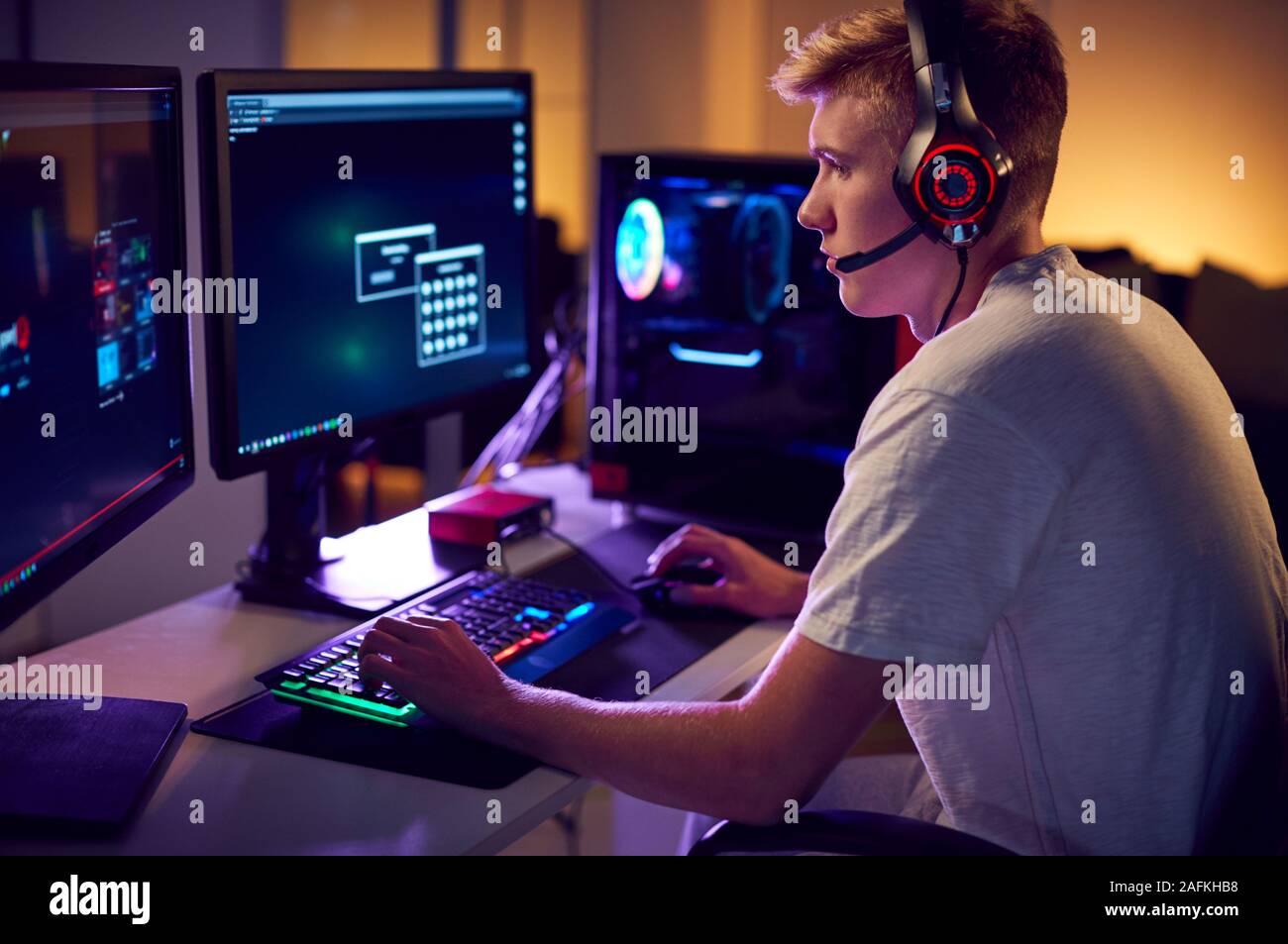 Male Teenage Hacker Sitting In Front Of Computer Screens Bypassing ...