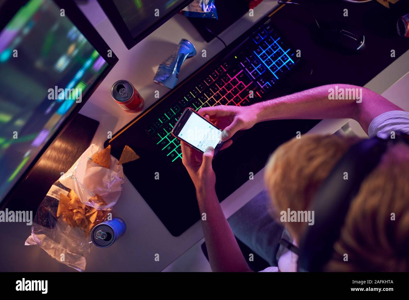 Overhead View Of Teenage In Front Of Computer Screens Trolling On ...