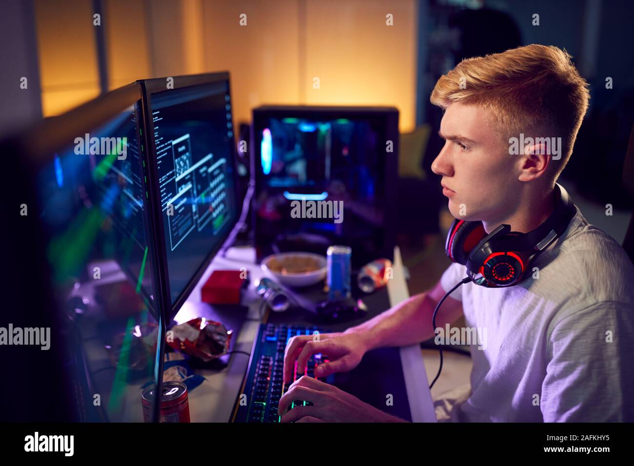 Male Teenage Hacker Sitting In Front Of Computer Screens Bypassing ...