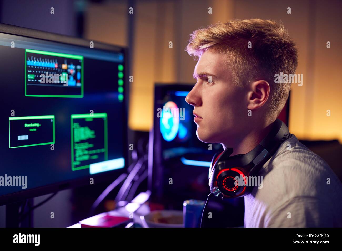 Male Teenage Hacker Sitting In Front Of Computer Screens Bypassing ...