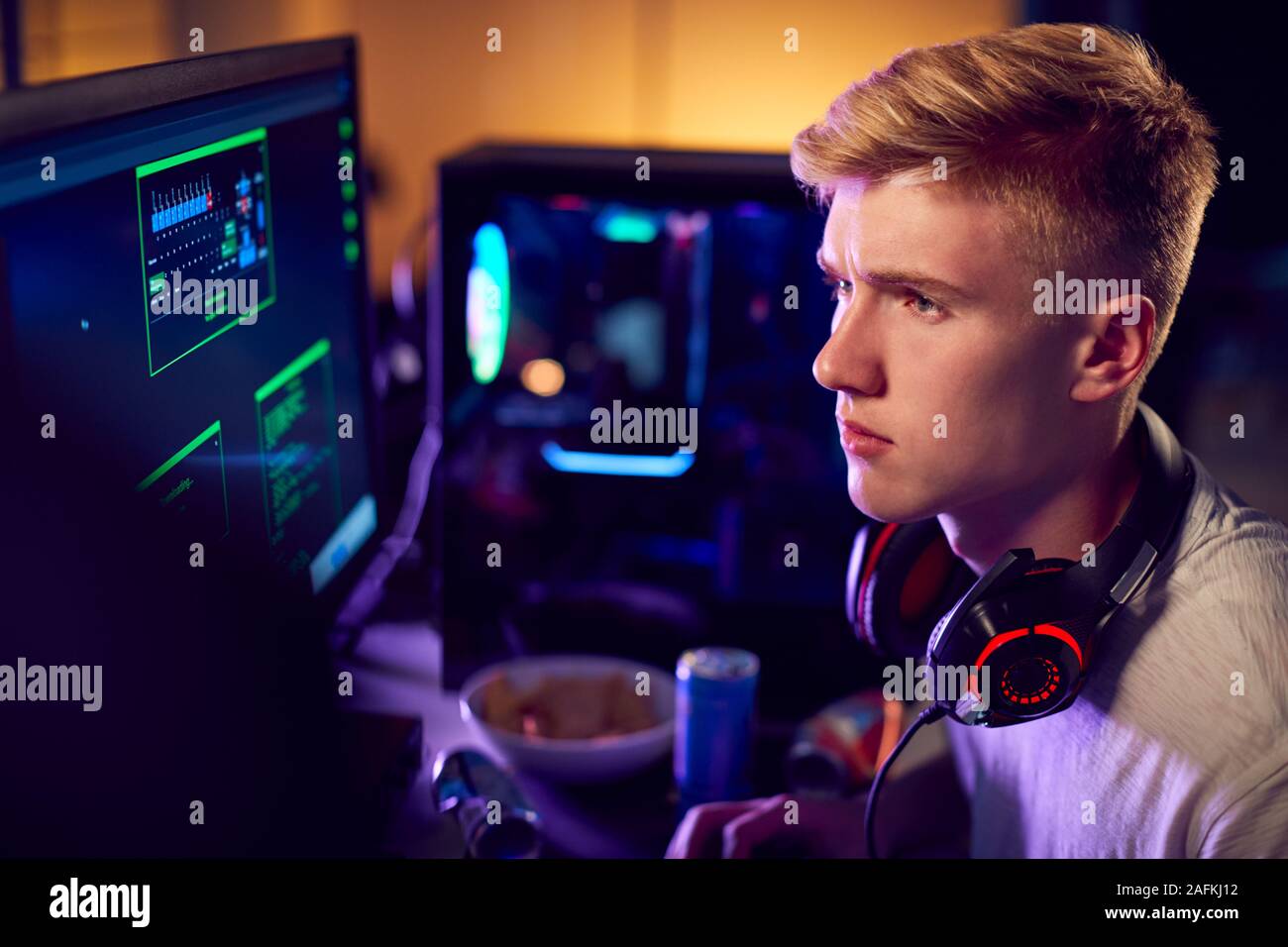 Male Teenage Hacker Sitting In Front Of Computer Screens Bypassing ...