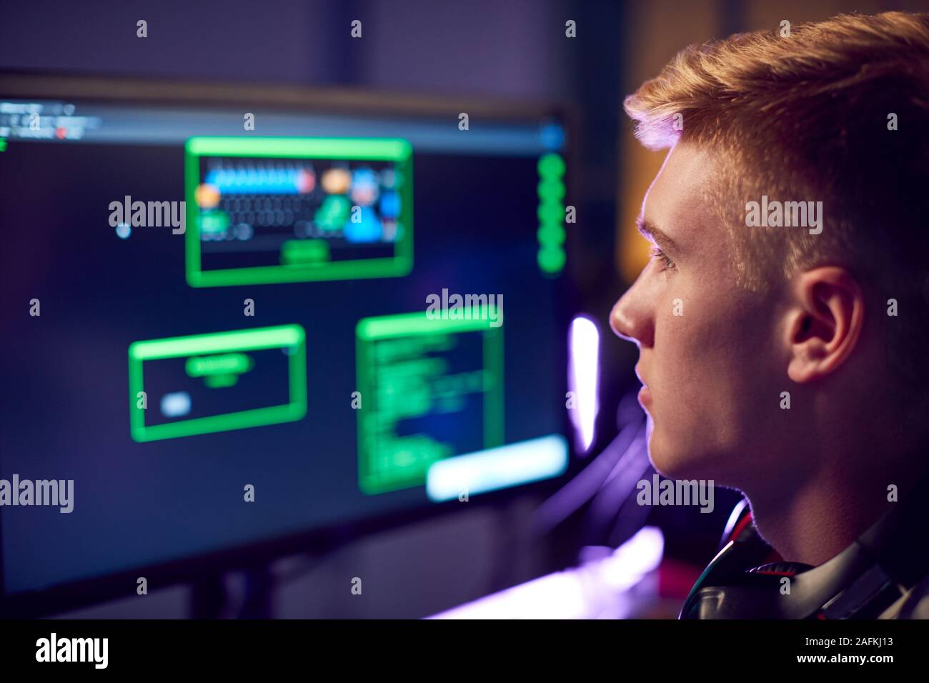 Male Teenage Hacker Sitting In Front Of Computer Screens Bypassing ...