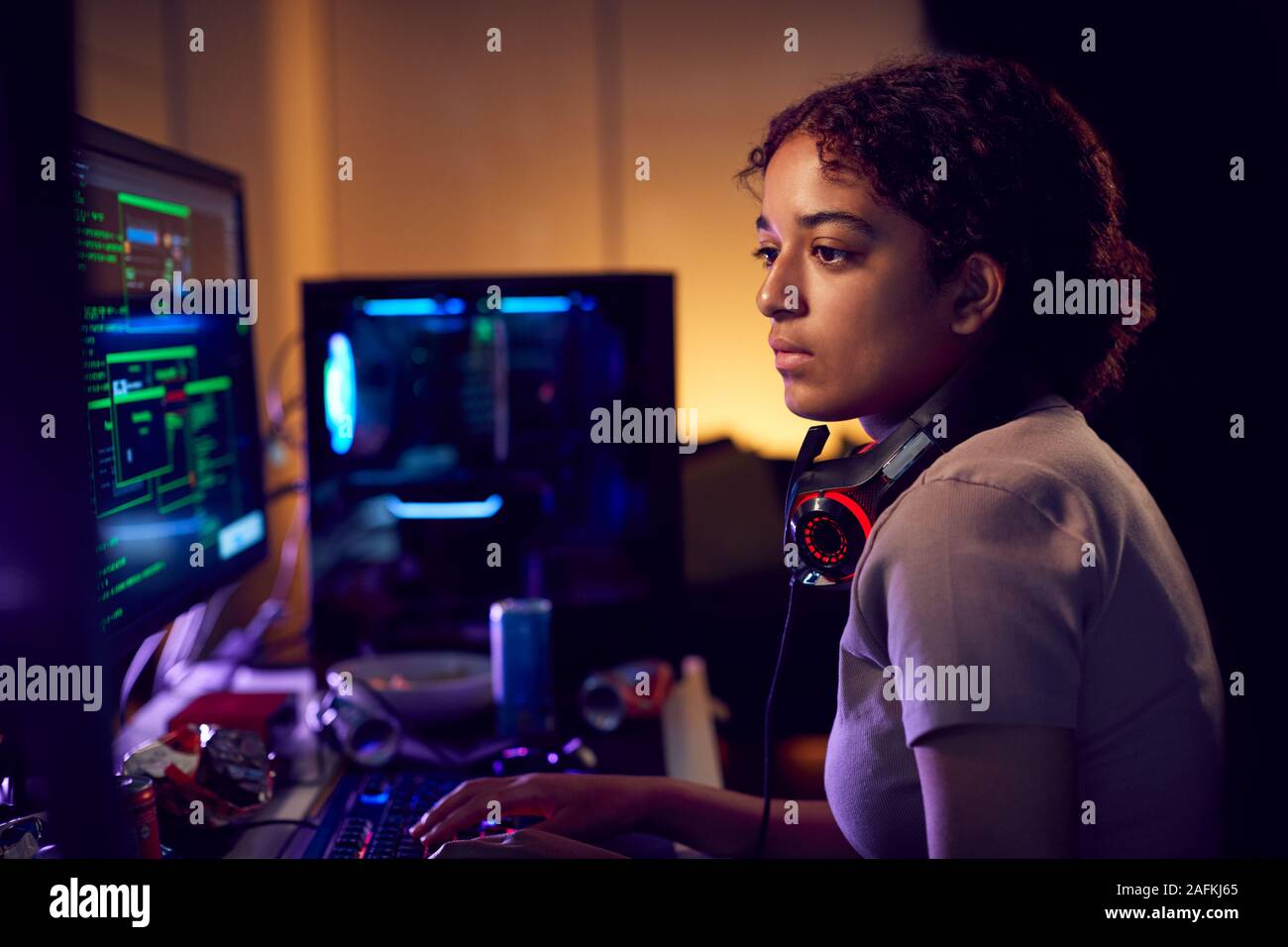 Female Teenage Hacker Sitting In Front Of Computer Screens Bypassing ...