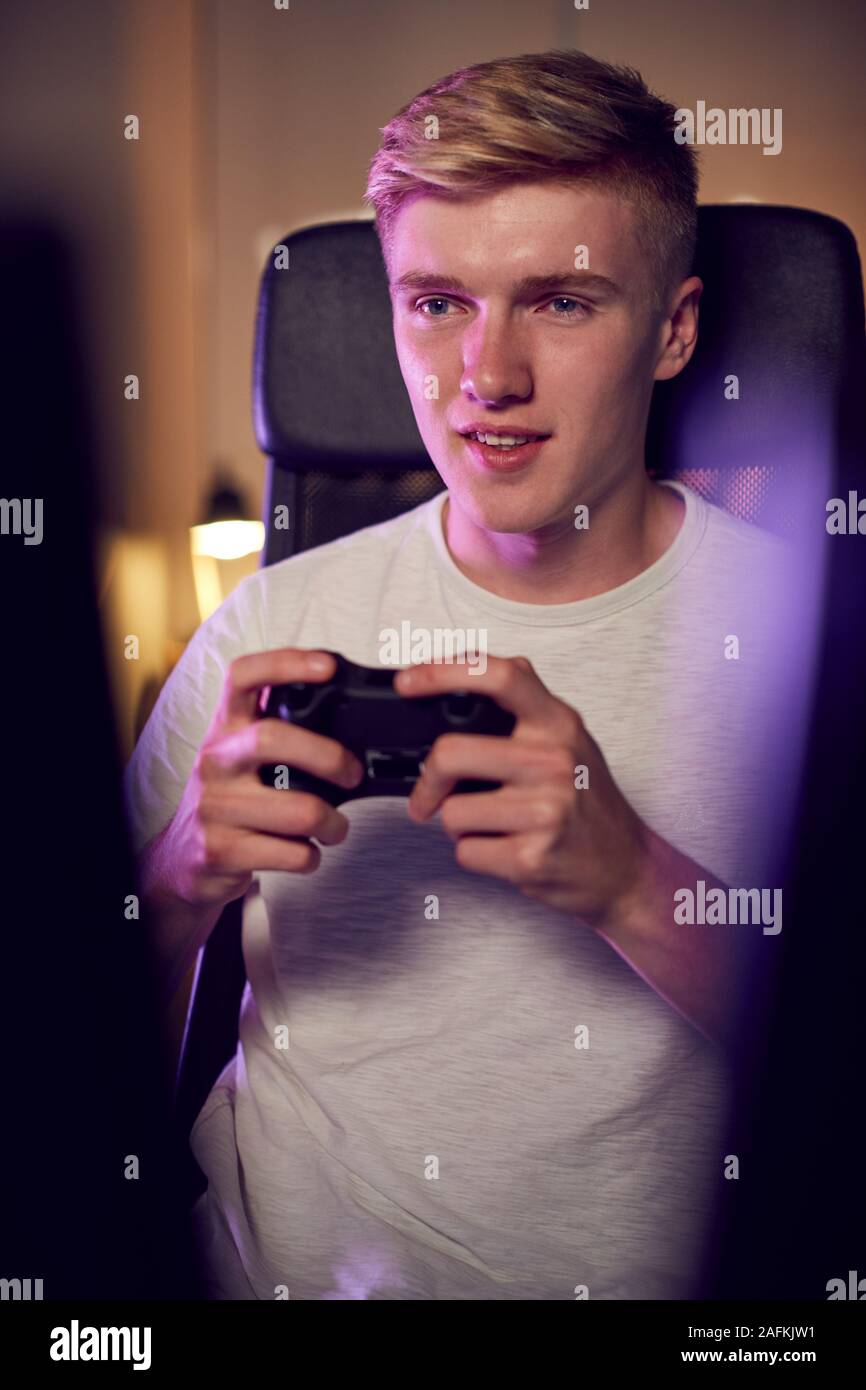 Teenage Boy With Game Pad Sitting In Chair and Gaming At Home Stock ...
