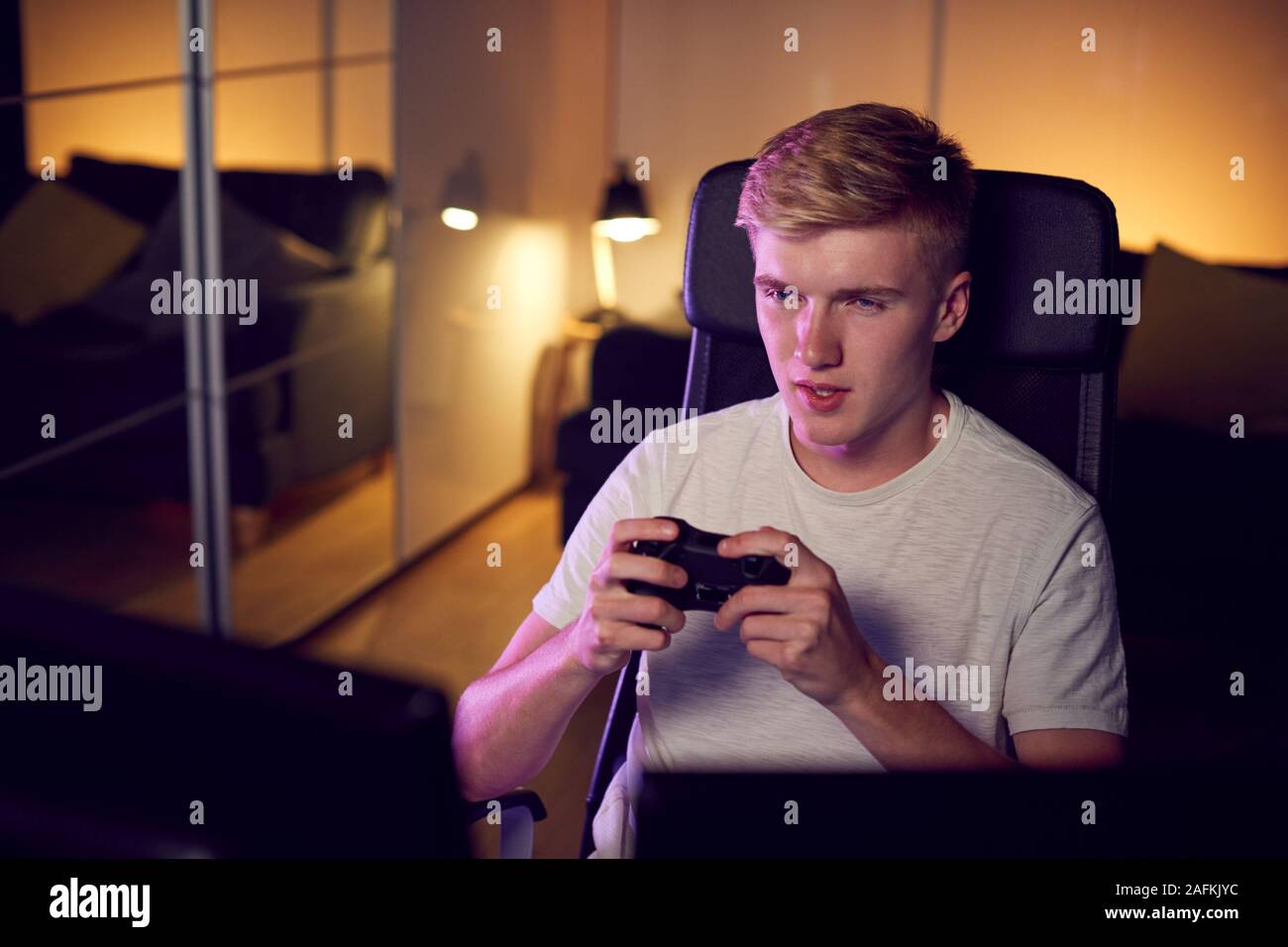 Teenage Boy With Game Pad Sitting In Chair and Gaming At Home Stock ...