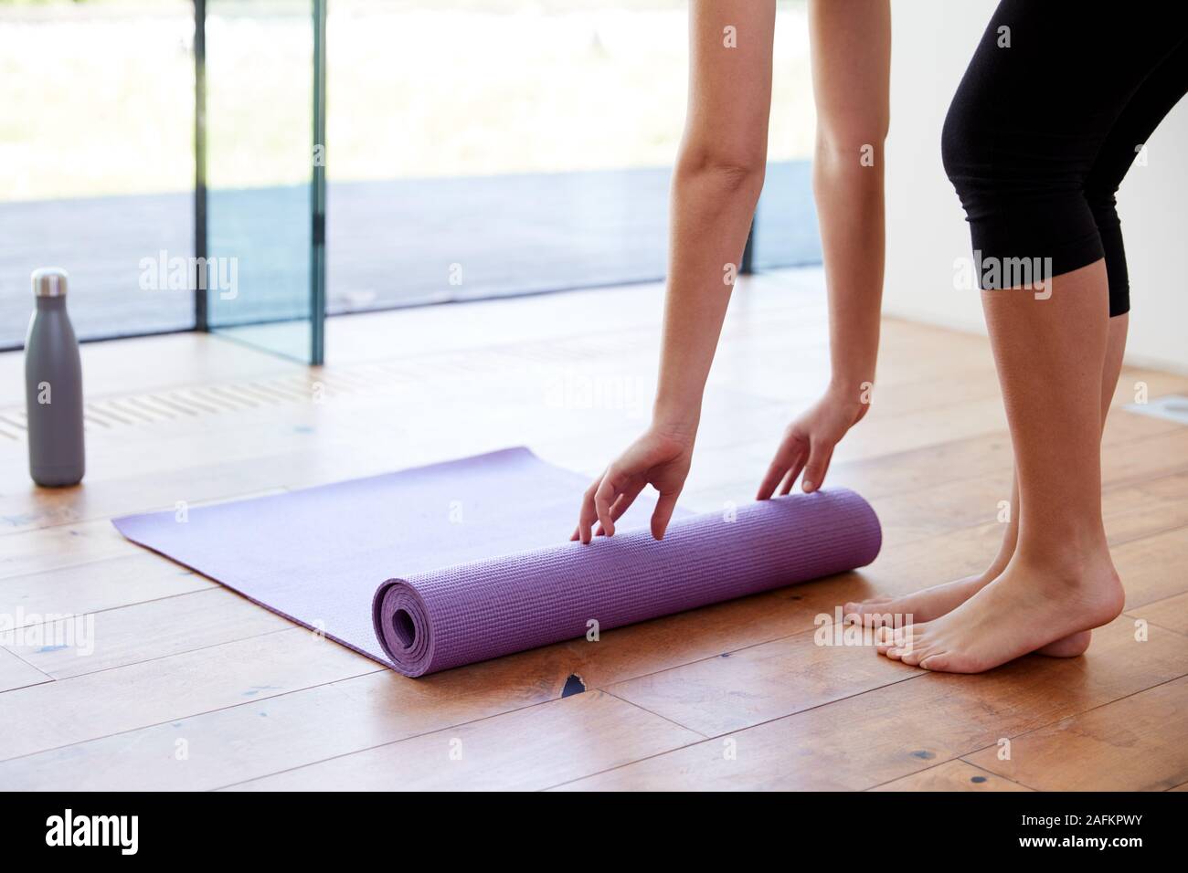 Close Up Of Woman Unrolling Yoga Mat Before Exercise Stock Photo - Alamy