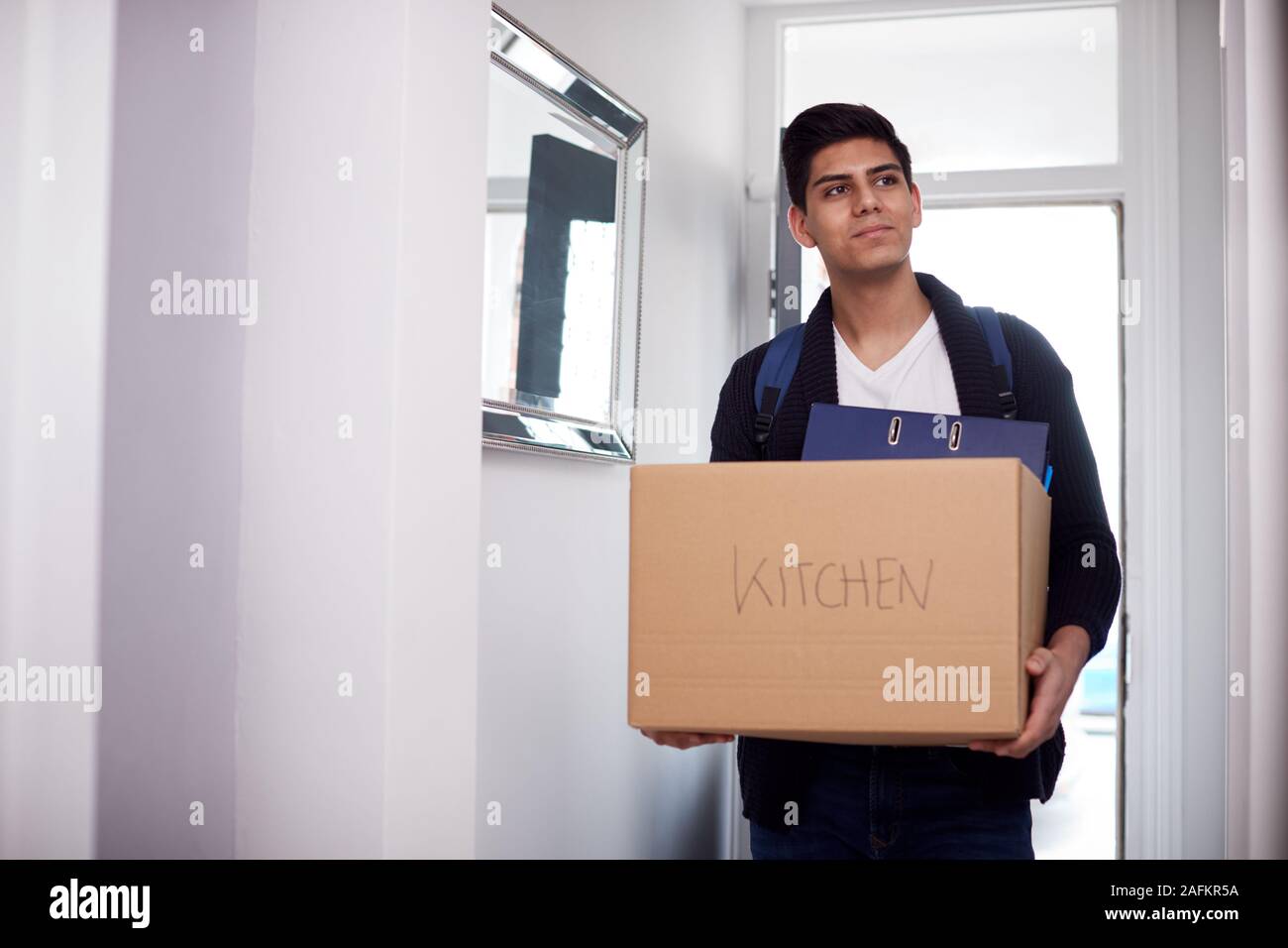 Male College Student Carrying Box Moving Into Accommodation Stock Photo ...