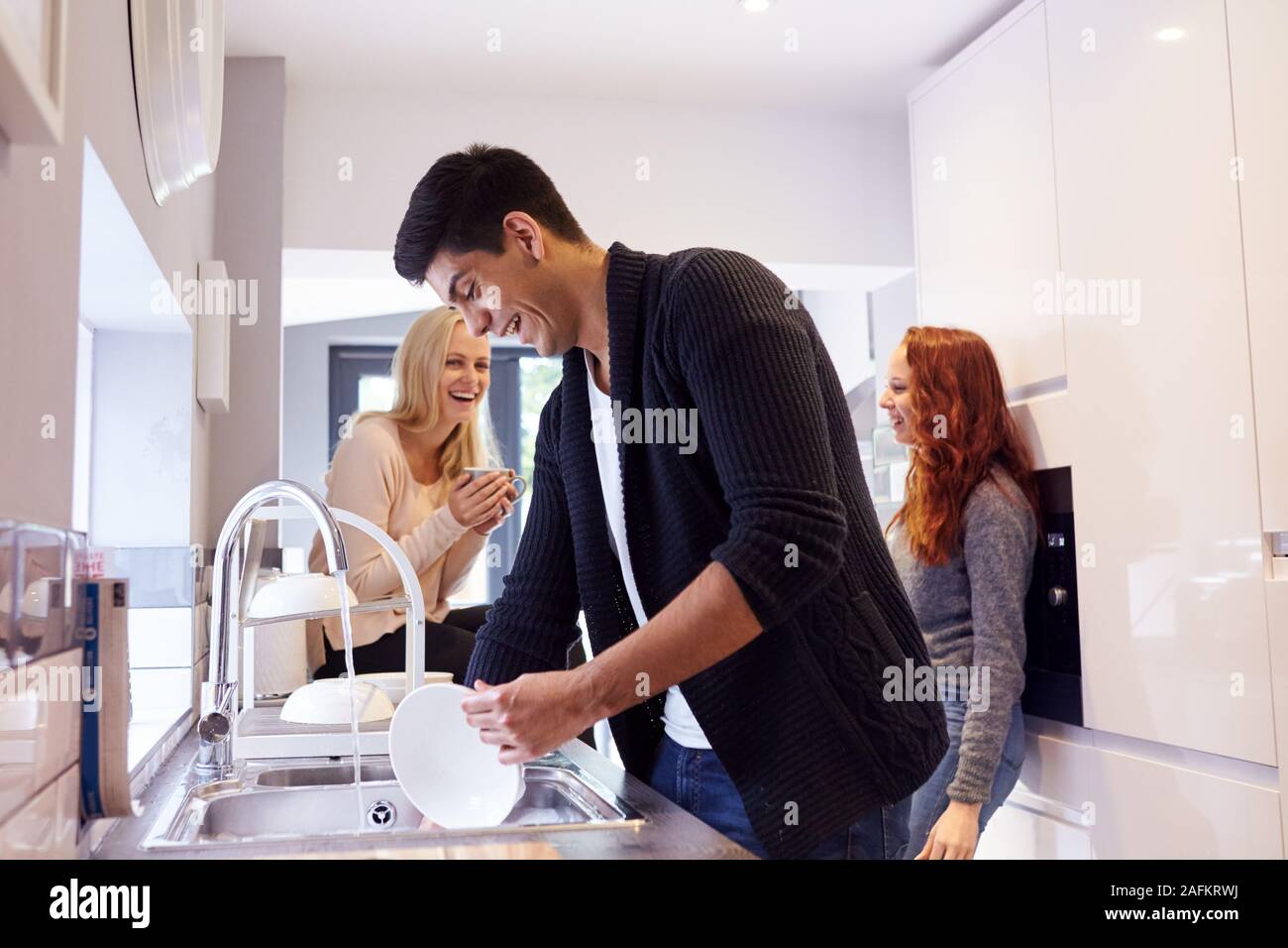 Group Of College Student Friends In Shared House Kitchen Washing Up And ...