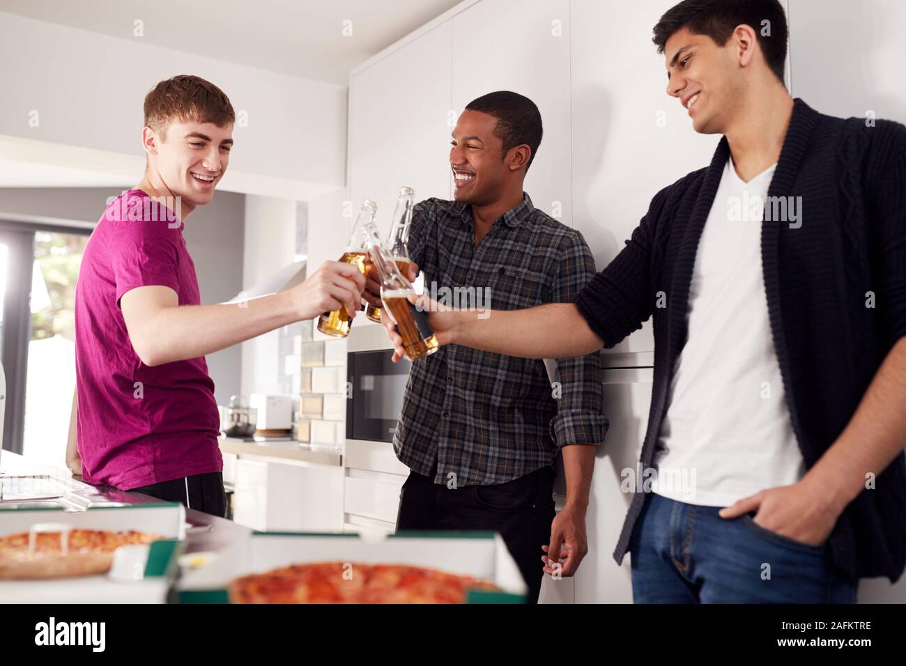 Group Of Male College Students In Shared House Kitchen Drinking Beer ...